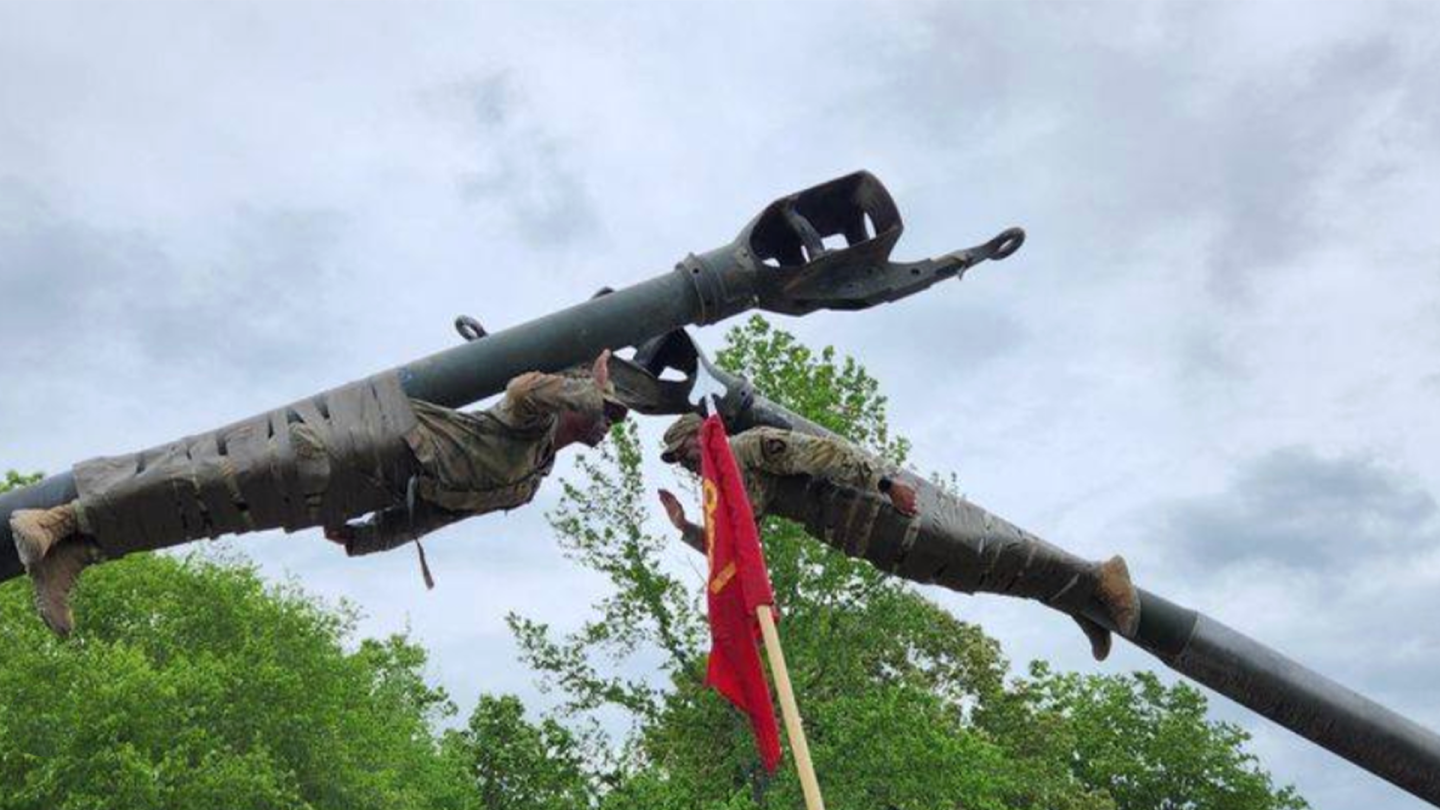 A soldier just reenlisted while taped to a Howitzer cannon